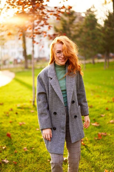 Redhead Smiling Pretty Woman Walking In Park On Sunny Autumn Day