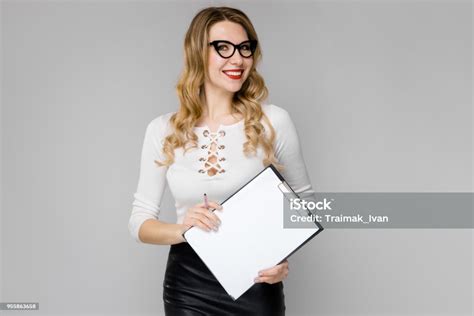 흑인과 백인 여 자가 매력적인 젊은 금발 비즈니스 사무실에 회색 배경에서 서 있는 그녀의 손에 웃는 표시 클립보드 옷 개념에 대한 스톡 사진 및 기타 이미지 Istock