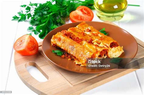 전통 이탈리아 파스타 Cannelloni입니다 구운된 관 파 르 마 치즈와 흰색 나무 테이블에 볘 샤 멜 소스와 다진된 고기와