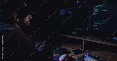 Cyber Terror Computer Hacker Sitting In A Dark Room In Front Of