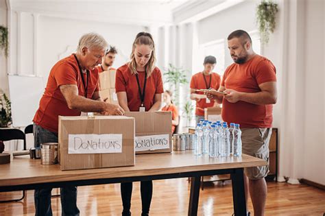 기부 센터의 자원 봉사자 팀 공유 및 포장 음식 옷 도움이 필요한 사람들을위한 상자에 물 개념에 대한 스톡 사진 및 기타 이미지 Istock