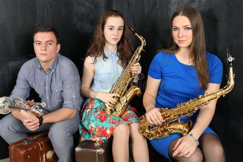 Man And Two Girls With Wind Instruments In Their Stock Image Image Of