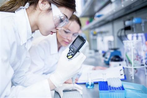 Lab Assistants Using Pipette Photograph By Science Photo Library