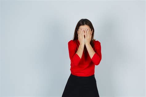Free Photo Young Lady Holding Hands On Face In Red Blouse Skirt And
