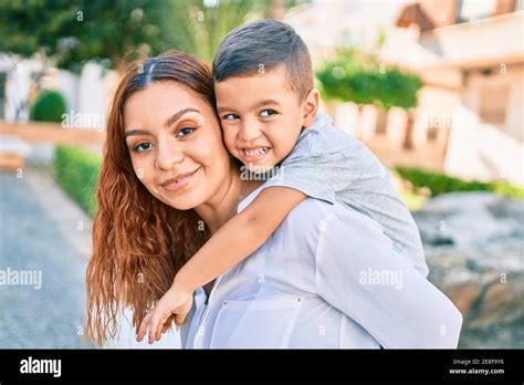 Adorable Latin Mother And Son Smiling Happy Hugging At The City Stock
