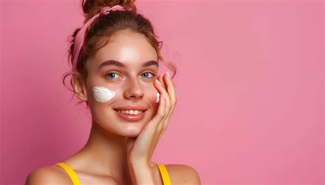 Premium Photo Young Woman Applying Sunscreen Cream On Pink Background