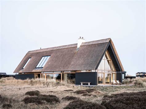 A Thatched Roof And Charred Wood Siding Were Used To Create This Modern