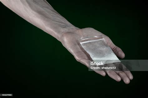 마약과 약물 중독 항목의 싸움 스튜디오에서 어두운 녹색 배경에 가방 중독 코카인을 들고 하는 더러운 손 고독 부정적인 감정