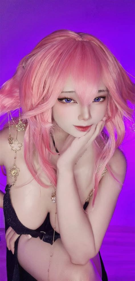 A Woman With Pink Hair Is Posing For The Camera