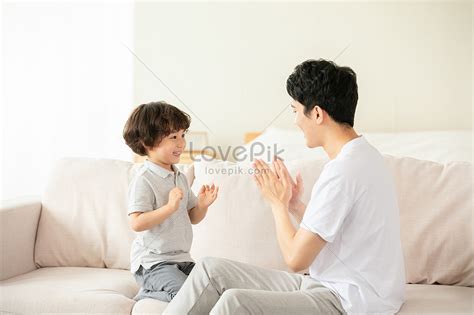 Father And Son Clapping Hands Clapping Game On The Sofa Picture And Hd