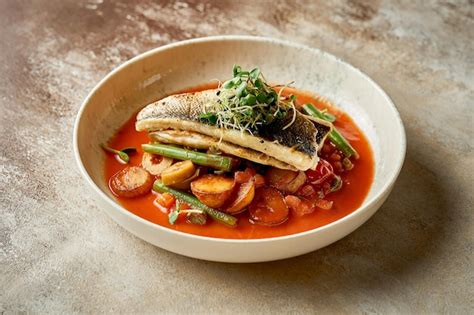 Premium Photo Fried Sea Bass Fillet With Potatoes In Tomato Sauce