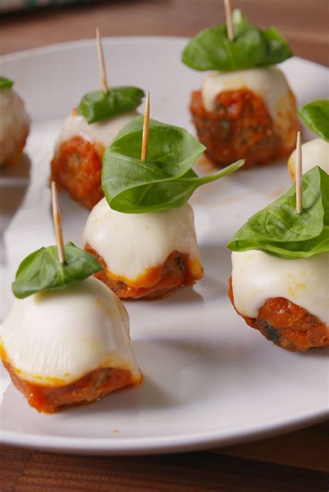 Small Appetizers With Cheese And Spinach Are On A White Plate Ready To