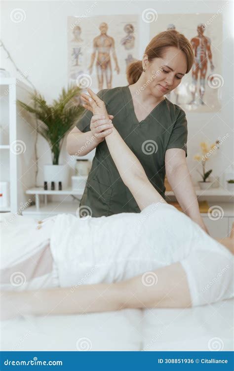 Happy Female Massage Therapist In Massage Cabinet Doing Checkup Stock