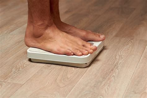 맨발을 가진 남자가 규모에 서 있다 사진은 바닥 비늘 및 발을 보여줍니다 개념에 대한 스톡 사진 및 기타 이미지 개념 건강