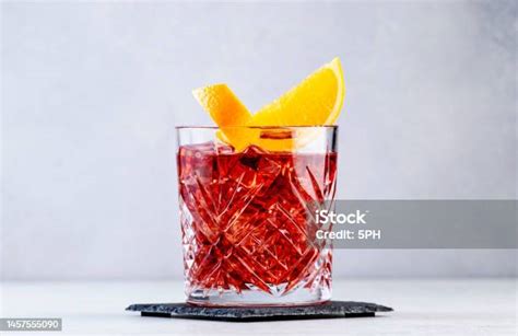 Negroni는 드라이 진 레드 버몬트 및 레드 비터 오렌지 슬라이스 및 아이스 큐브를 곁들인 인기있는 알코올 칵테일입니다 회색