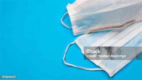 파란색 배경에 입과 코를 덮기 위해 고무 패드가있는 일회용 수술 용 얼굴 마스크 두 개 박테리아 의료 및 의학으로부터 보호의