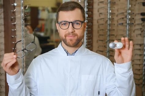 Premium Photo Male Doctor Holding Contact Lens Case And Glasses Indoors