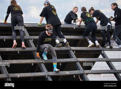 Group Of Women Climbing The Slip Wall Obstacle At The Spartan Race