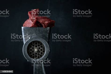 검은 배경에 수동 고기 분쇄기에서 쇠고기 미트볼을 위해 다진 고기 만들기 매크로 샷 날고기로 금속 고기 분쇄기를 닫습니다 강철에