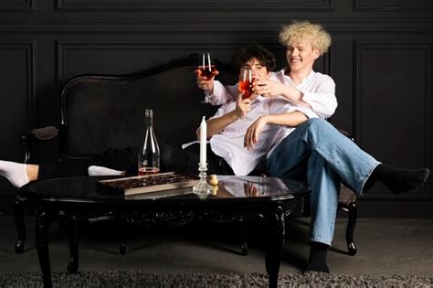 Zwei junge Männer feiern mit einer Flasche Champagner Romantischer Abend an dem das schwule