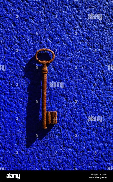 Rusty Brass Key On The Blue Wall Stock Photo Alamy