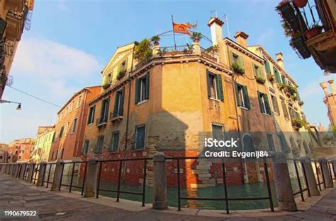 베니스 거리의 그림 같은 풍경 고대 노란색 건물 청록색 물이있는 좁은 운하가있는 전형적인 거리 코너 건물을 따라 아름다운 조약돌 통로 베니스 이탈리아 거리에 대한 스톡 사진