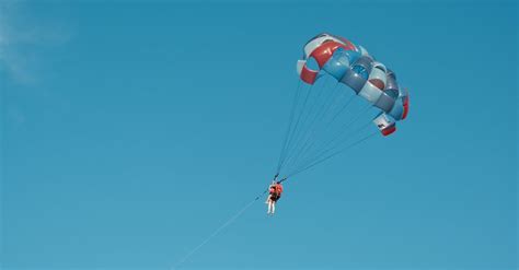 맑은 하늘을 배경으로 한 신나는 패러세일링 모험 · 무료 스톡 사진