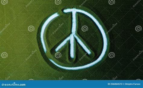 Hand Drawing The Pacific Peace Symbol In The Green Sand And Then Erases