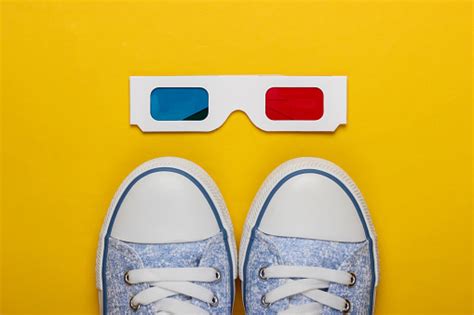 노란 배경에 구식 스타일의 운동화와 Anaglyph 일회용 종이 3d 안경 맨 위 보기입니다 복고풍 80년대 1990 1999