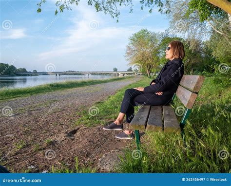 Senior Elegan Woman Relaxing With Her Legs Crossed Sitting On A Park