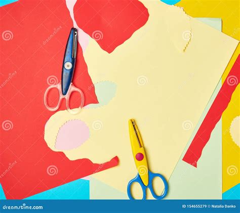 Pair Of Plastic Scissors And Colored Paper For Cutting Figures Stock