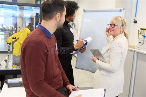 Engineers Discussing Robot Automation And Programming In A Modern