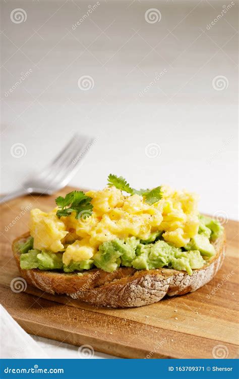 Tostada Con Aguacate Machacado Y Huevo Revuelto Imagen De Archivo