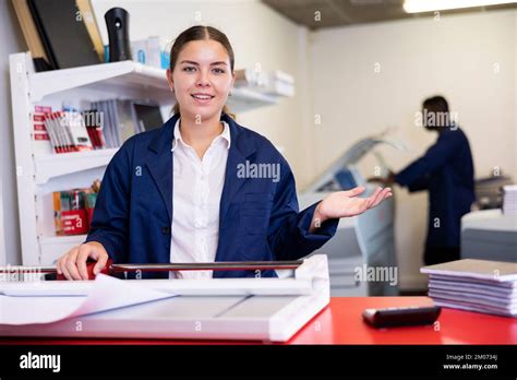 Portrait Of Cheerful Young Female Typographer In Uniform Using Paper