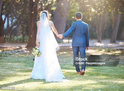 자연에서 함께 걷는 신혼 부부의 뒷모습 촬영 신부와 신랑은 자연에서 여름날 함께 걷고있는 동안 손을 잡고 남편이 길을 인도하는
