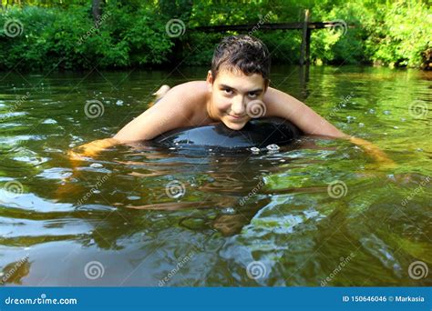 Il Ragazzo Si Diverte Su Una Tubatura Nel Fiume Fotografia Stock