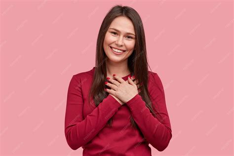 Free Photo Touched Positive Woman With Pleased Expression Keeps Hands