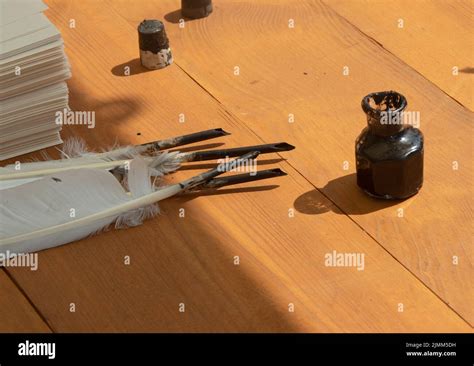 A Stack Of Quill Pens With An Inkwell For The Signing Copies Of The