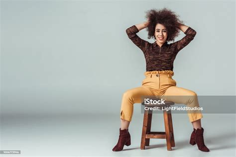 복고풍 옷을 자에 앉아서 회색에 카메라 보고 행복 한 흑인 여자 고풍스런에 대한 스톡 사진 및 기타 이미지 고풍스런 목재