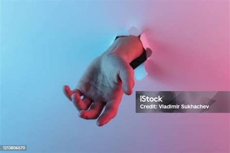 신비한 할로윈 개념입니다 찢어진 구멍을 통해 손 창조적 인 팝 아트 핑크 블루 네온 색상입니다 트렌디 한 그라데이션 조명 야간 조명 강렬하고 밝은 색상에 대한 스톡 사진 및