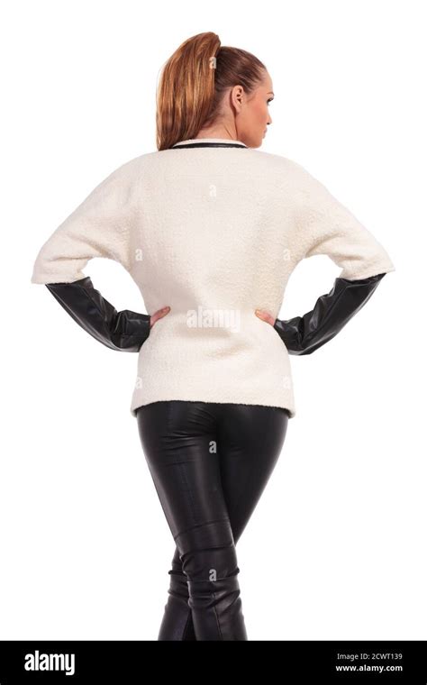 Rear View Of A Young Fashion Woman Standing With Her Legs Crossed While