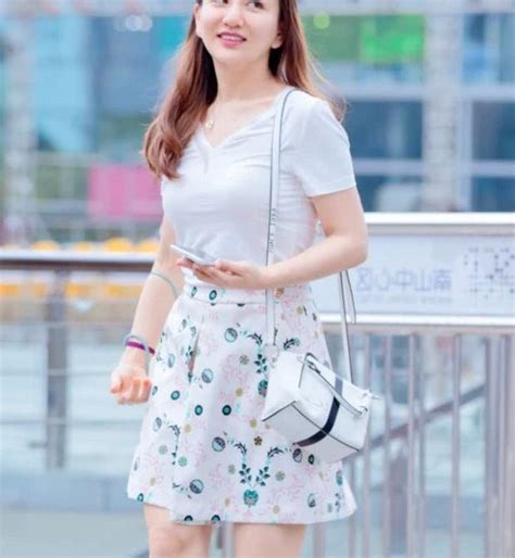 街拍：小姐姐身穿白色t恤搭印花短裙，尽显青春年华