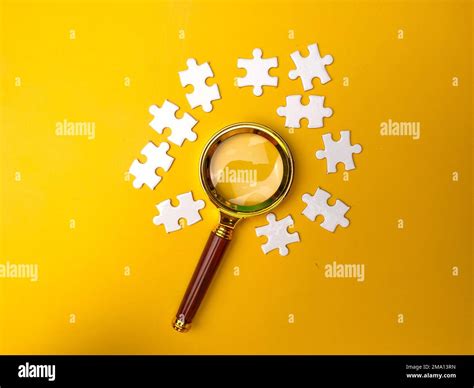 Magnifying Glass Searching Missing Puzzle On Yellow Background Stock