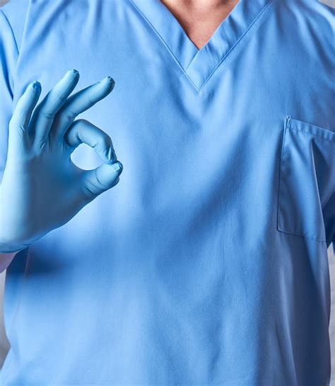 Doutor Em Uniforme Azul E Luvas Estéreis De Látex Mostra Um Símbolo De