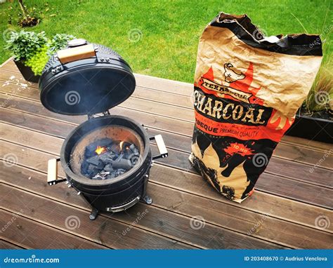 A Kamado Type Barbeque Grill With A Bag Of Charcoal On A Terrace