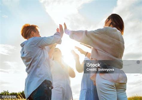 손을 잡고 웃고 있는 네 명의 여성들의 초상화는 야외 산책 중에 하이파이브를 하고 있다 그들은 카메라를 보고 있습니다 여자의