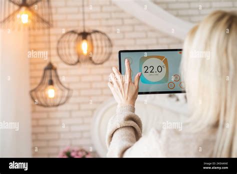 Woman Controlling Smart Home Devices Using A Digital Tablet With Launched Application In The