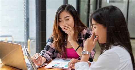 도서관에서 함께 그룹 과제를 하는 동안 놀라움을 느끼는 두 젊은 여학생의 측면 사진 Unsplash의 테이블 이미지