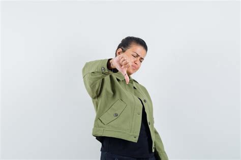 Леди показывает палец вниз в куртке Бесплатно Фото