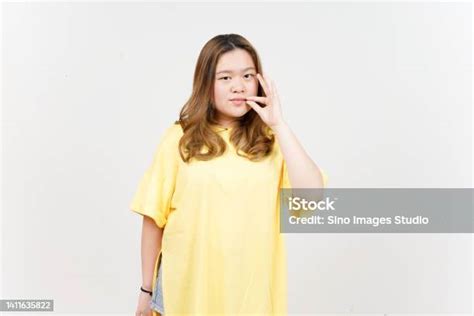 흰색 배경에 고립 된 노란색 티셔츠를 입은 아름다운 아시아 여성의 비밀 입술을 닫으십시오 18 19세에 대한 스톡 사진 및 기타